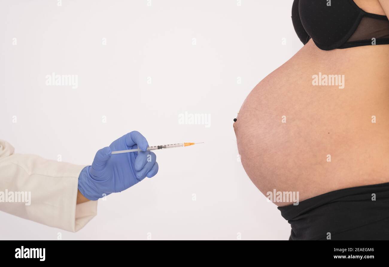 Young pregnant woman's belly about to receive an injection Stock Photo ...