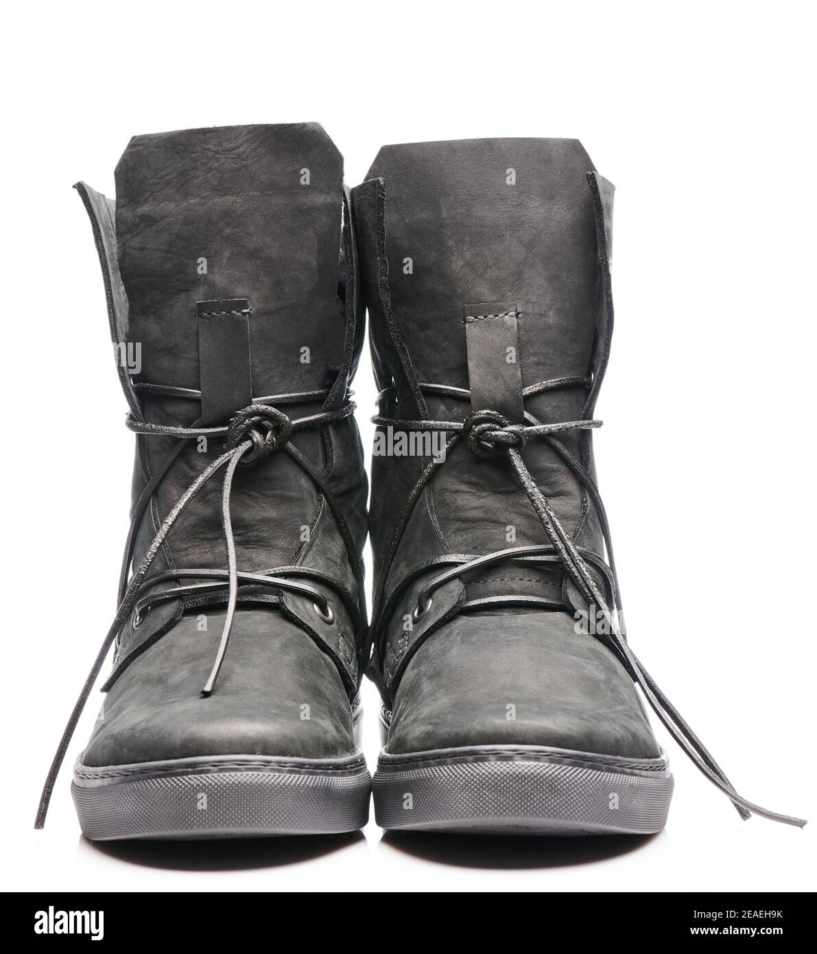 Pair of black leather boots front view isolated on studio background ...