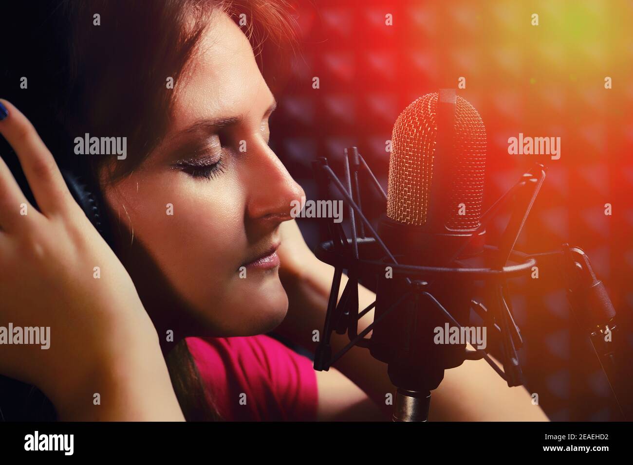 Young woman holding headphones, close-up. The singer face next to the ...