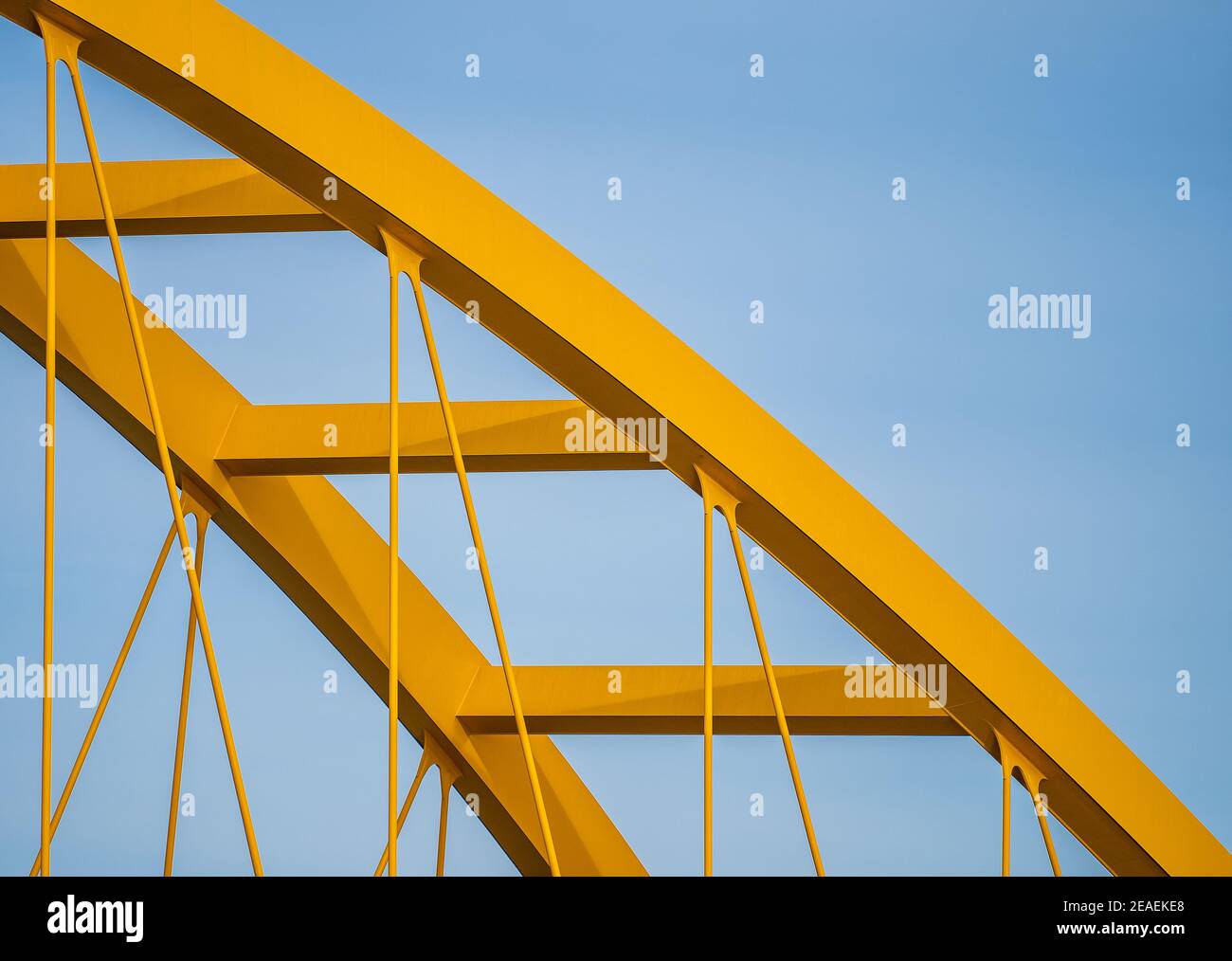 Yellow steel arch of a bridge against the blue sky Stock Photo - Alamy