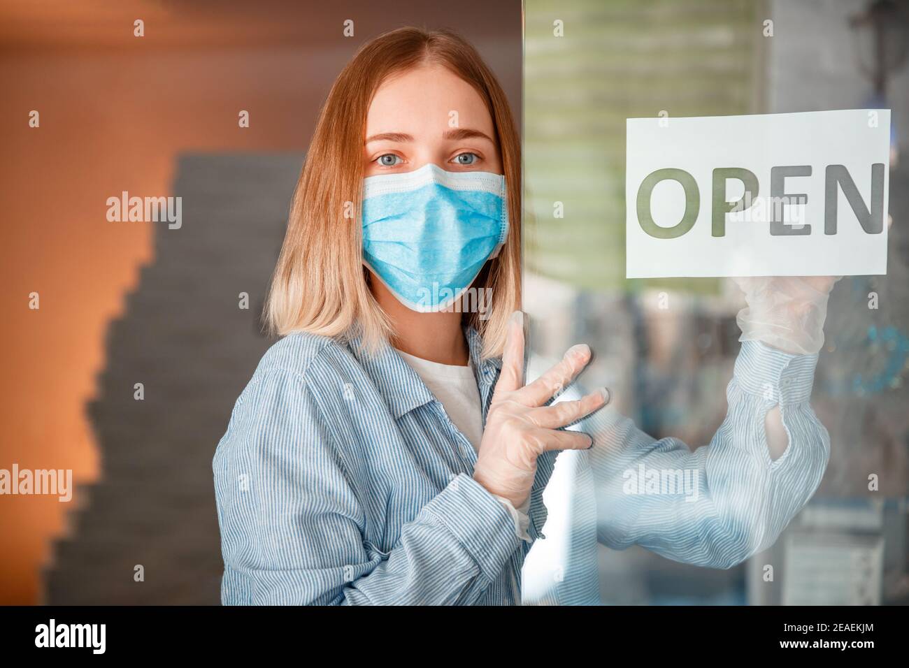 Sign Open welcome on shop entrance door as new normal.Young woman ...