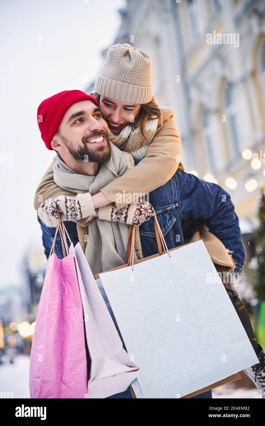 Merry woman riding boyfriend in winter city Stock Photo - Alamy