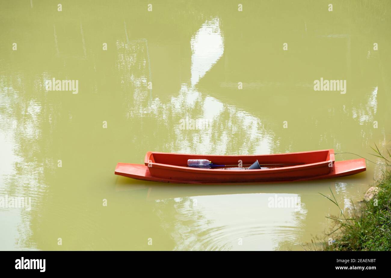 Leaky plastic row boats with the paddle are floating near the banks of ...