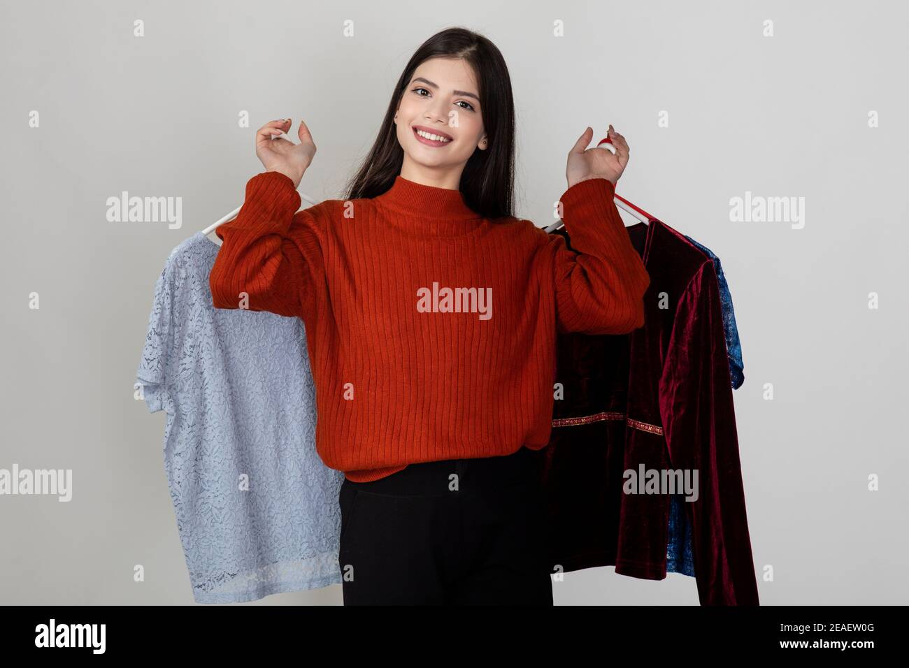 Portrait of pretty young Indian girl standing against white background ...