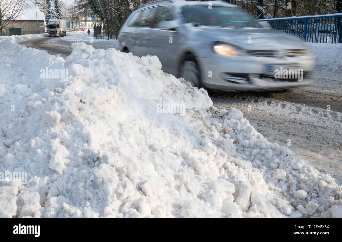 Bielefeld, Germany. 09th Feb, 2021. A car drives past a pile of snow ...