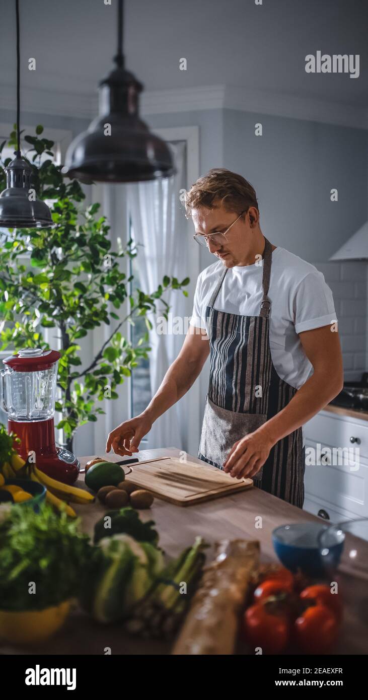 Handsome Man in White Shirt and Apron is Making a Healthy Organic Salad ...