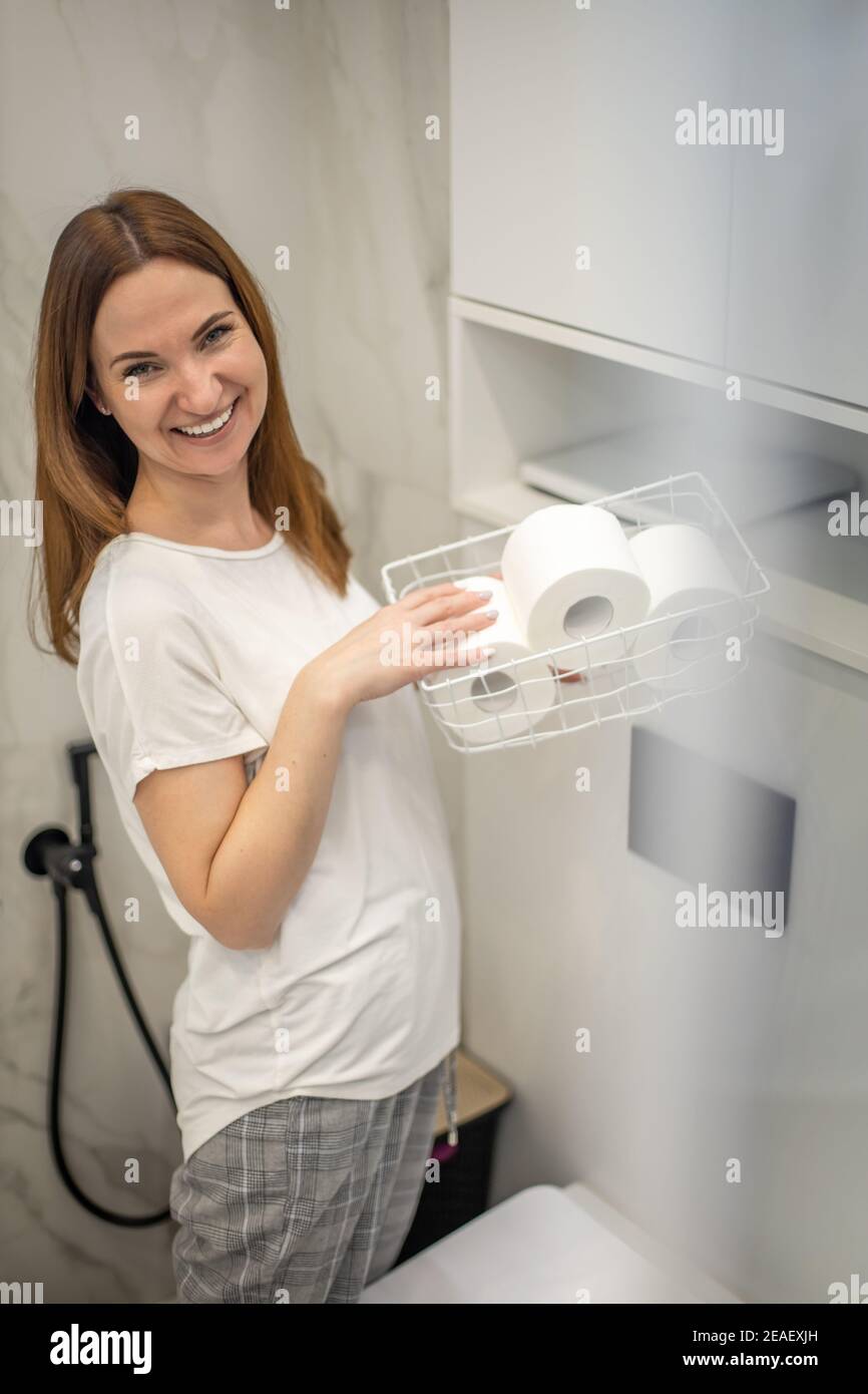 Young woman is organizing and placing metal mesh with toilet paper ...