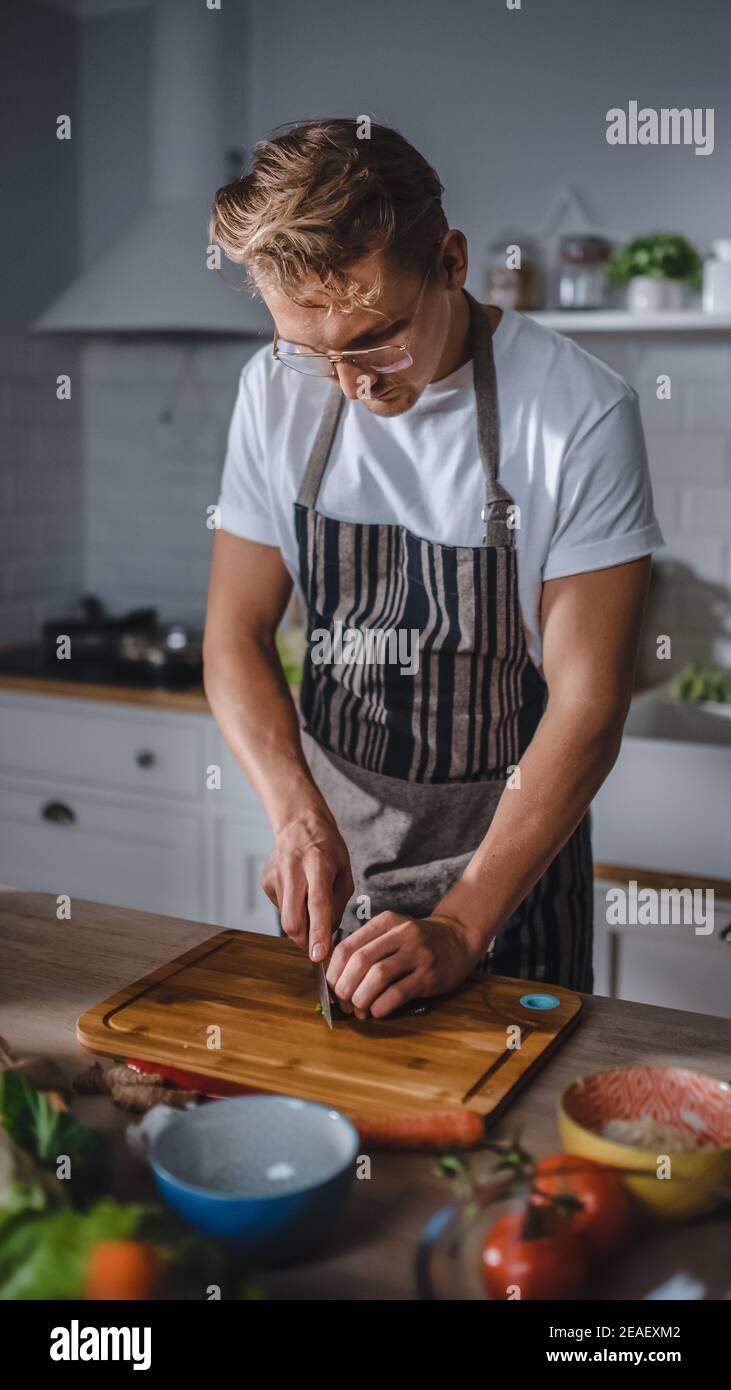 Handsome Man in White Shirt and Apron is Making a Healthy Organic Salad ...
