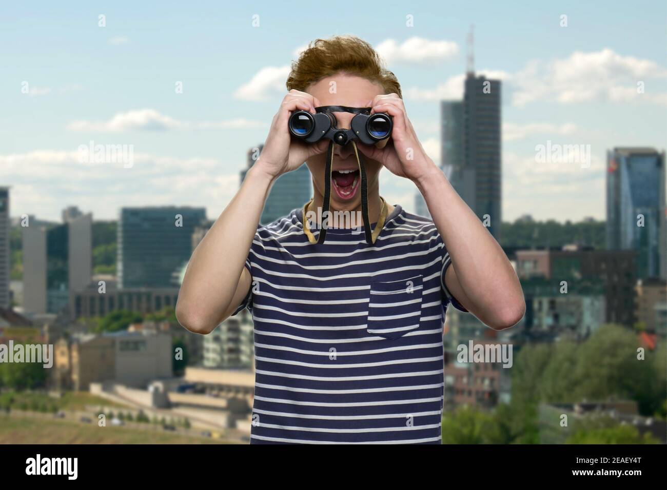 Shocked young teen boy looks through binoculars Stock Photo - Alamy