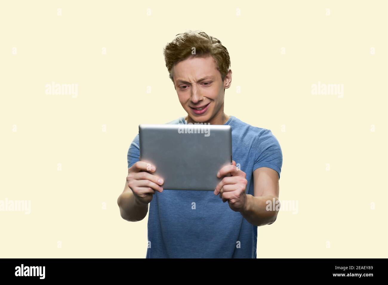 Crying teen boy is looking at the tablet Stock Photo - Alamy