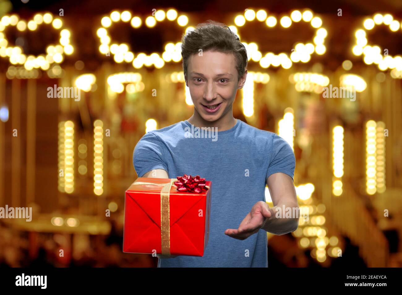 Handsome young boy is giving you a present Stock Photo - Alamy