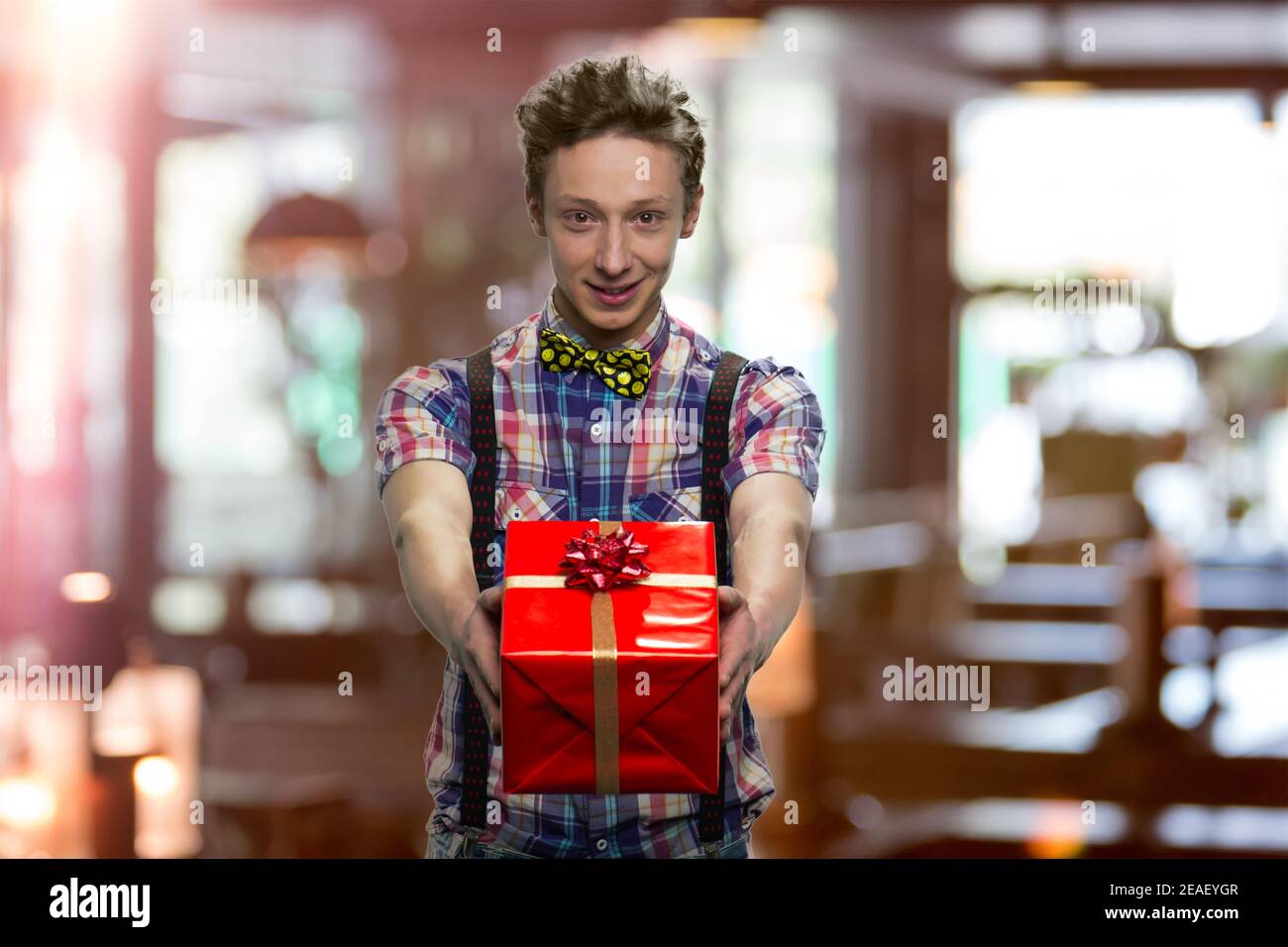 Handsome young boy is giving you a present Stock Photo - Alamy