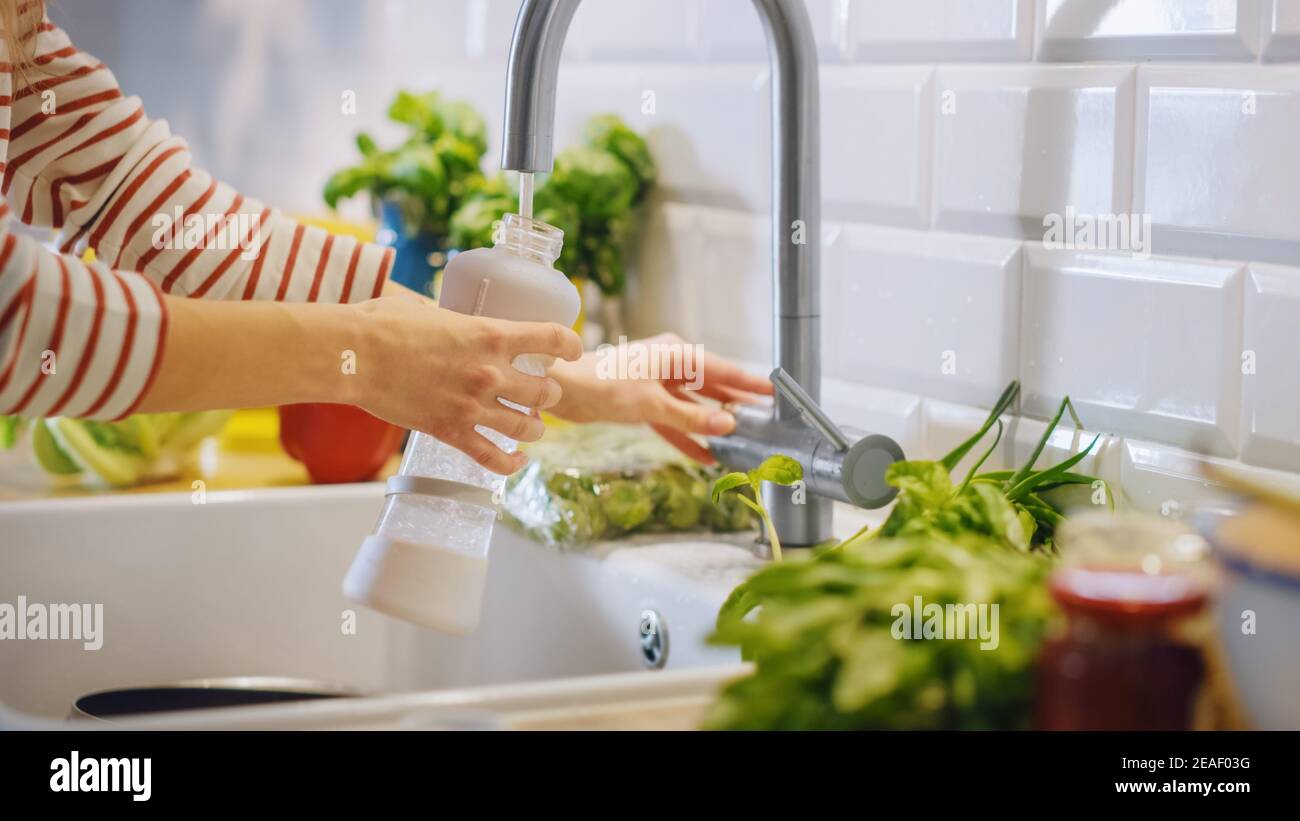 Close Up Shot of a Woman Filling a Reusable Plastic Bottle with Clean ...