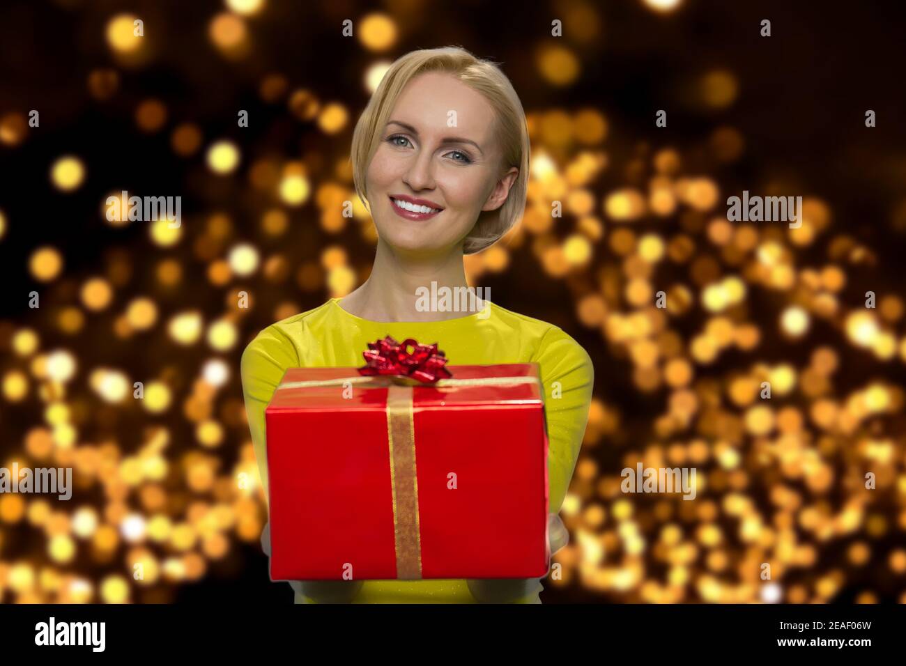 Cheerful mature woman is giving you a present Stock Photo - Alamy