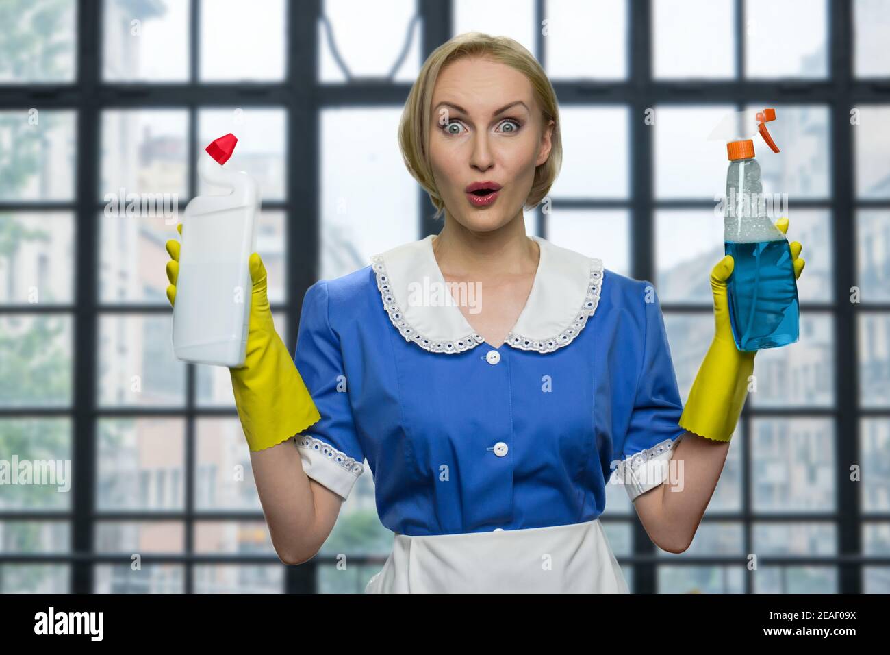 Surprised cleaning lady is raising her arms Stock Photo - Alamy
