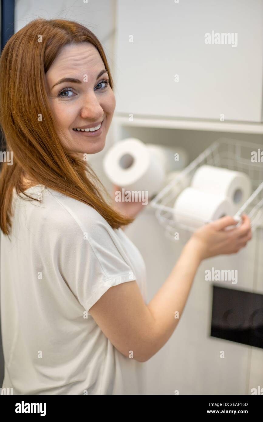 Young woman is organizing and placing metal mesh with toilet paper ...