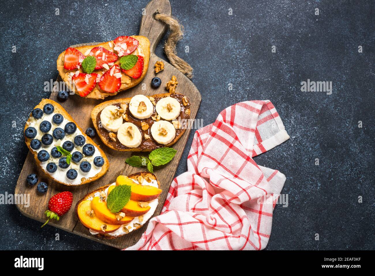 Sweet toast assortment with fresh fruit and berries on black Stock ...