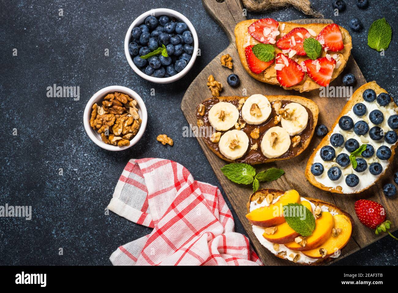 Sweet toast assortment with fresh fruit and berries on black Stock ...