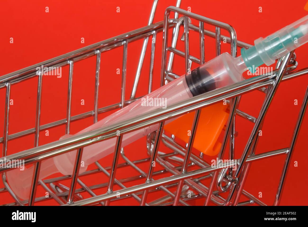 A medical syringe in the small shopping cart or trolley. The idea of ...