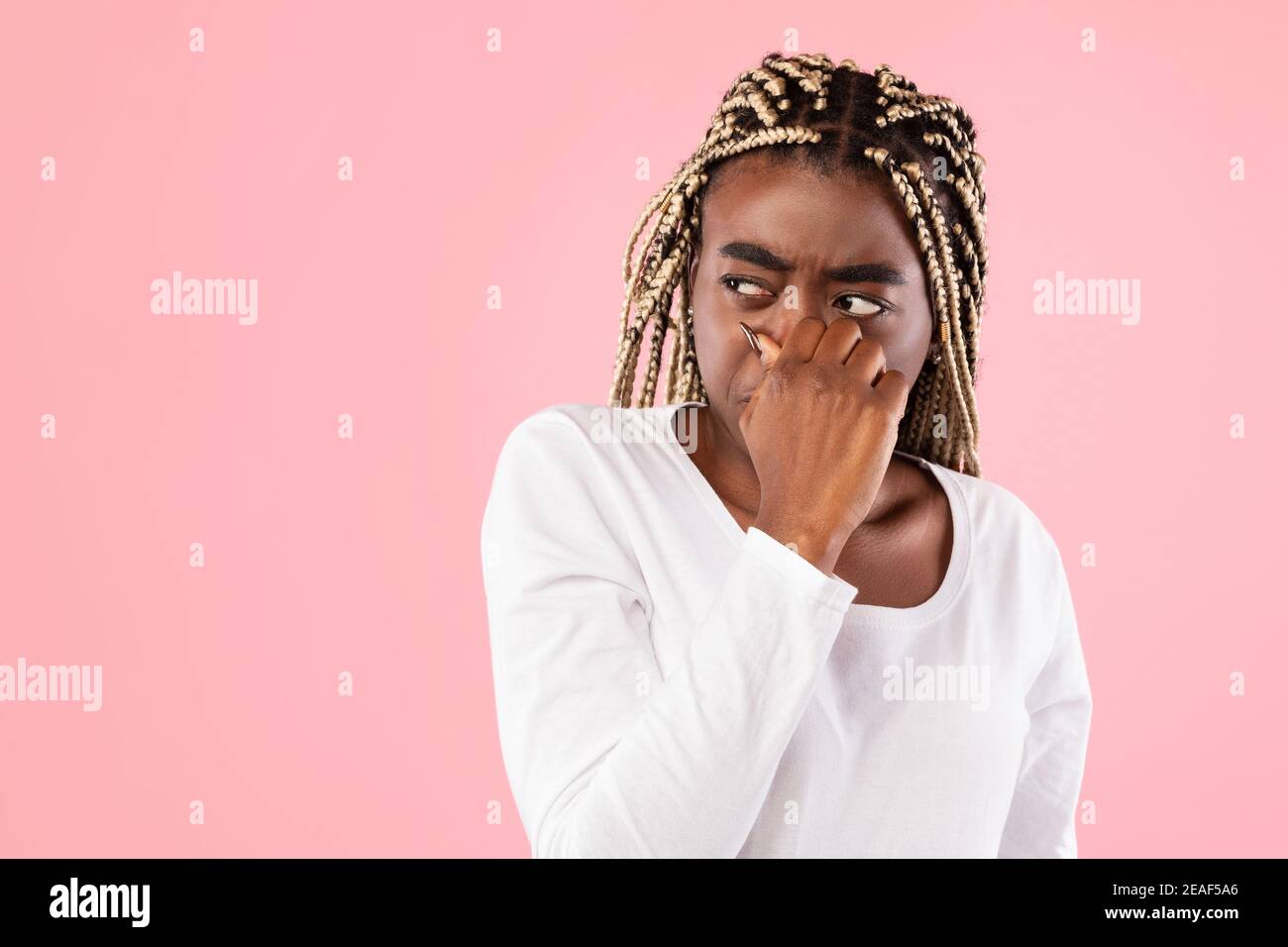Displeased african american woman plugging her nose, smells something ...