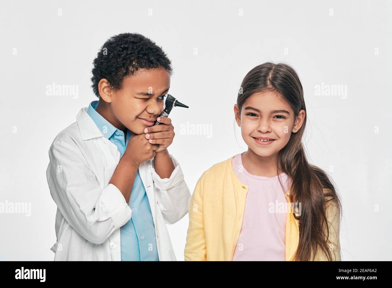 African American boy doing ear exam to Asian girl uses an otoscope ...