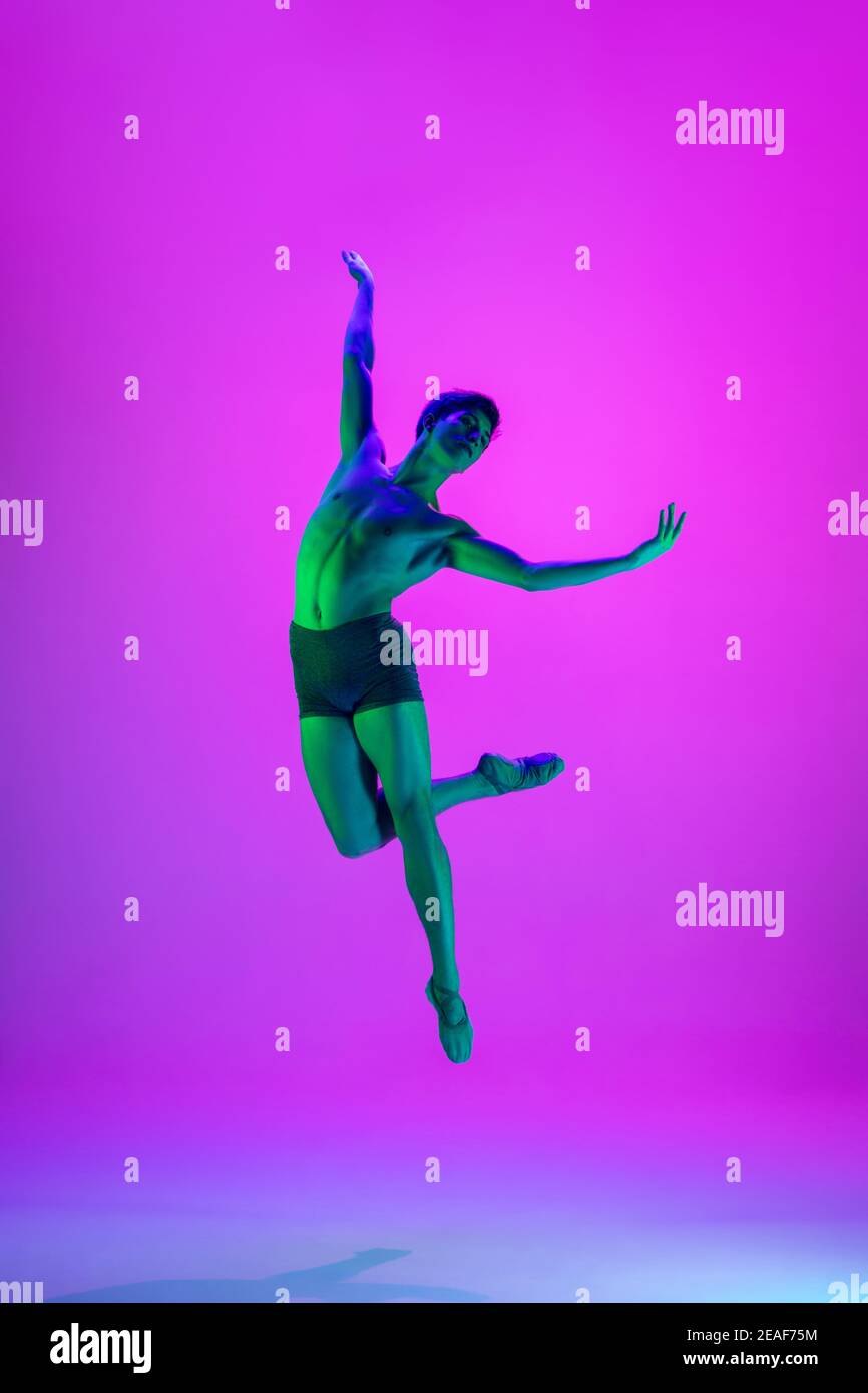 Emotions. Young and graceful ballet dancer on purple studio background ...