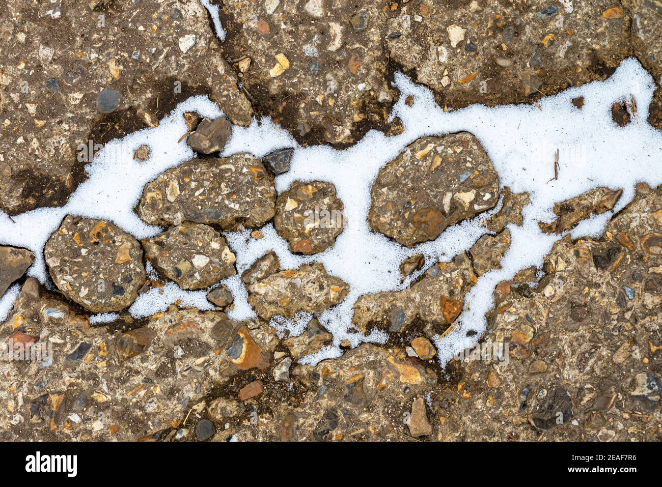 Snow in the cracks of a concrete ground Stock Photo - Alamy