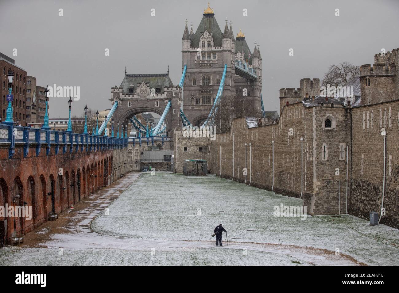A groundsman forks the snow covered moat surrounding The Tower of ...