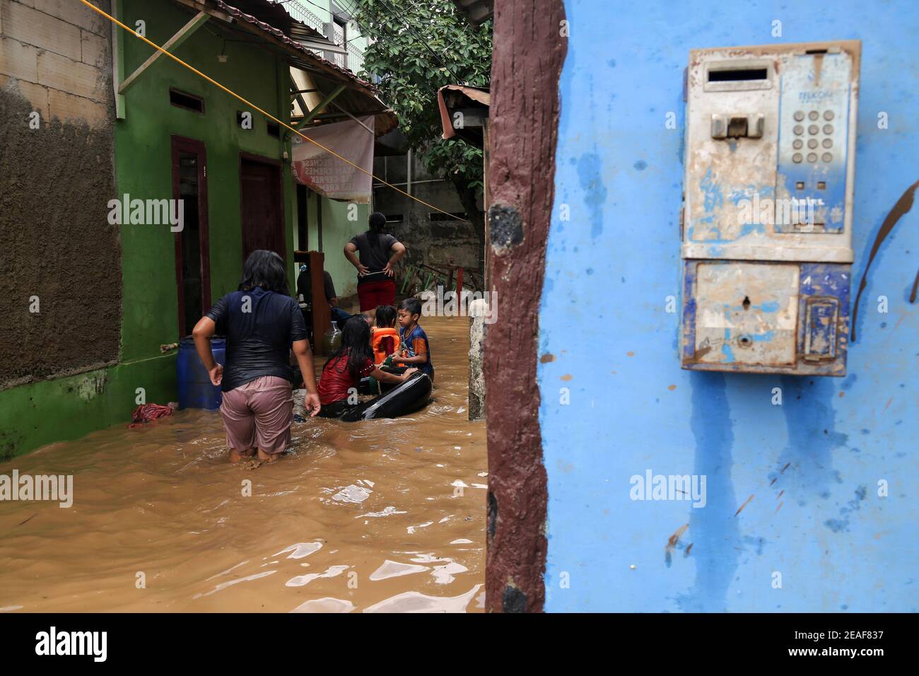 Children play in floodwaters using rubber tires during the aftermath of ...