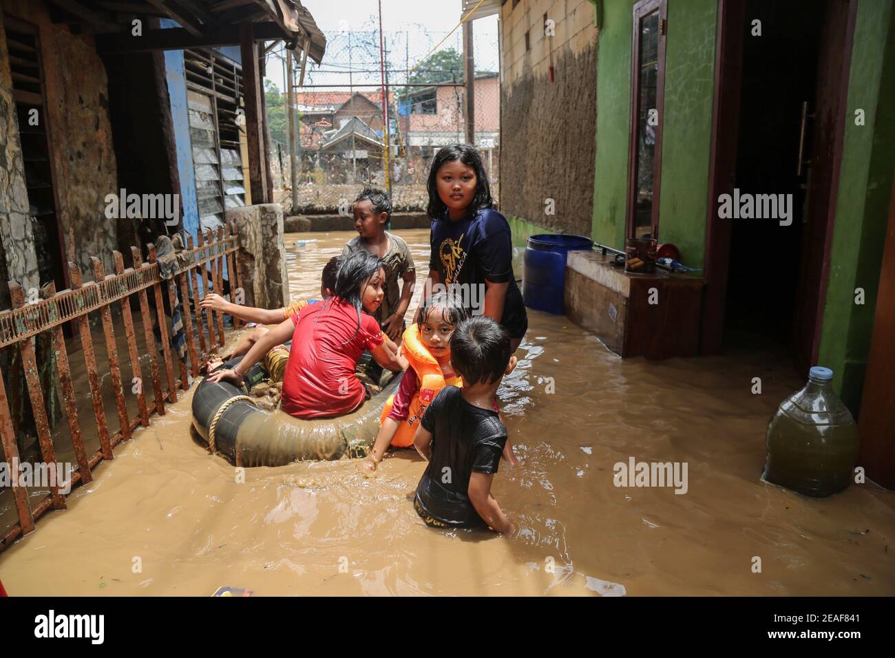 Children play in floodwaters using rubber tires during the aftermath of ...