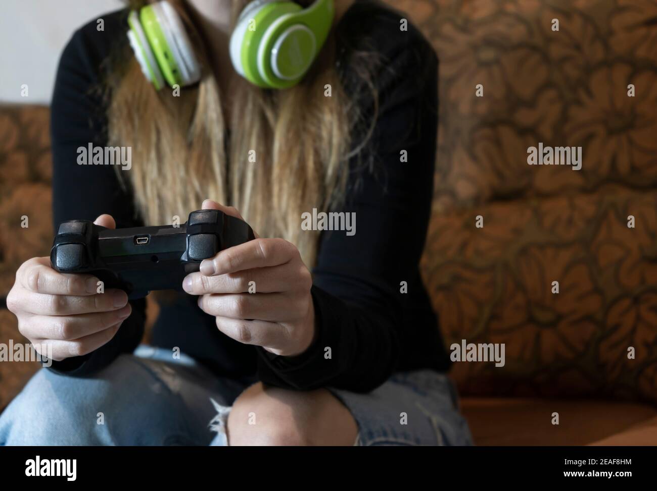 Young woman playing video games on couch at home.Selective focus on ...
