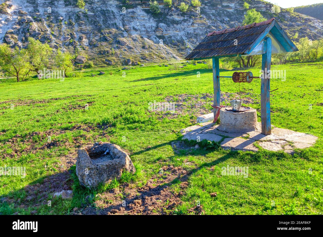 Old well on the meadow . Water well on countryside in beautiful spring ...