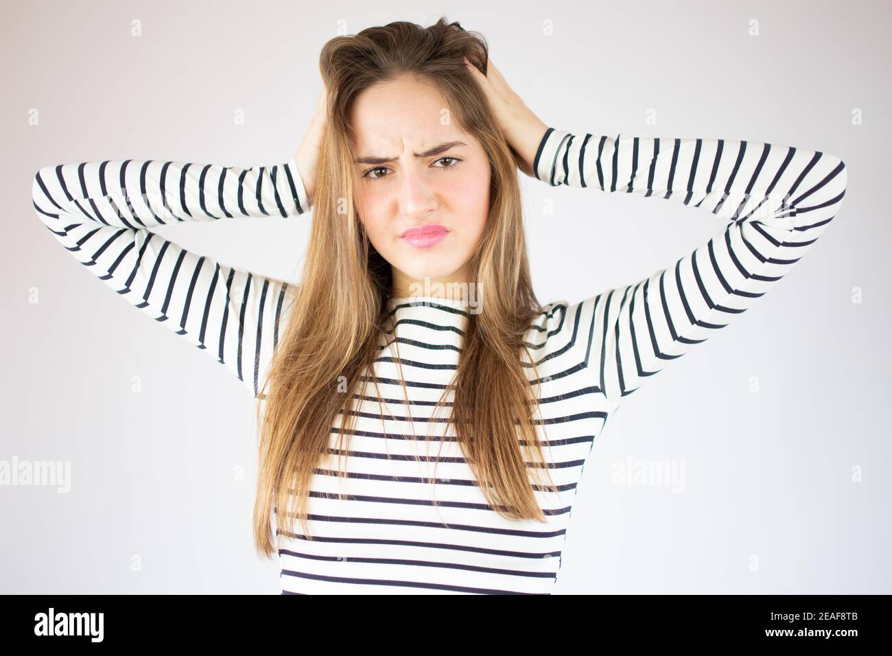 Portrait of preoccupied worried young girl in pink shirt putting hand ...