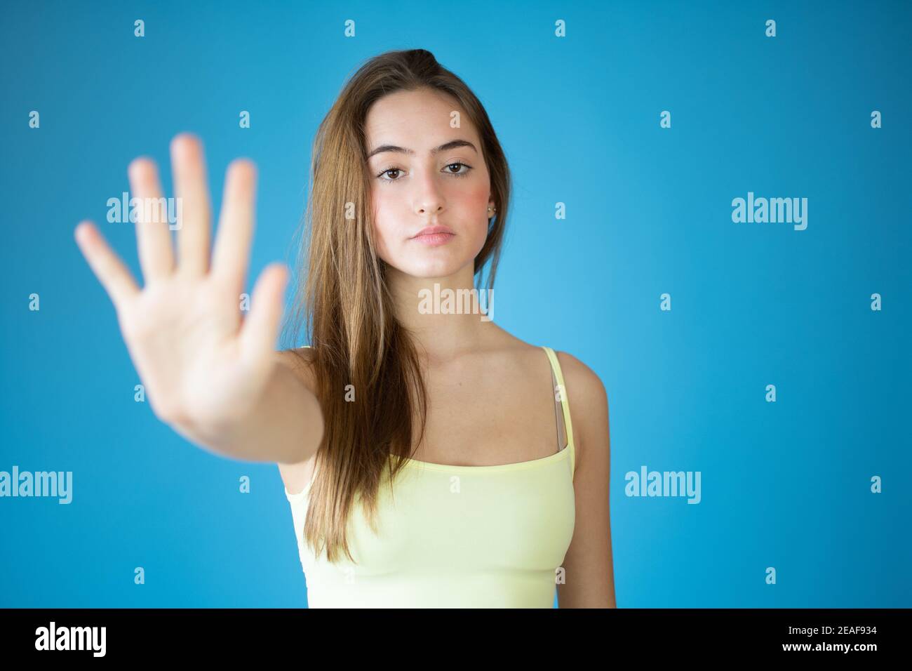 Portrait of a serious young girl standing with outstretched hand ...