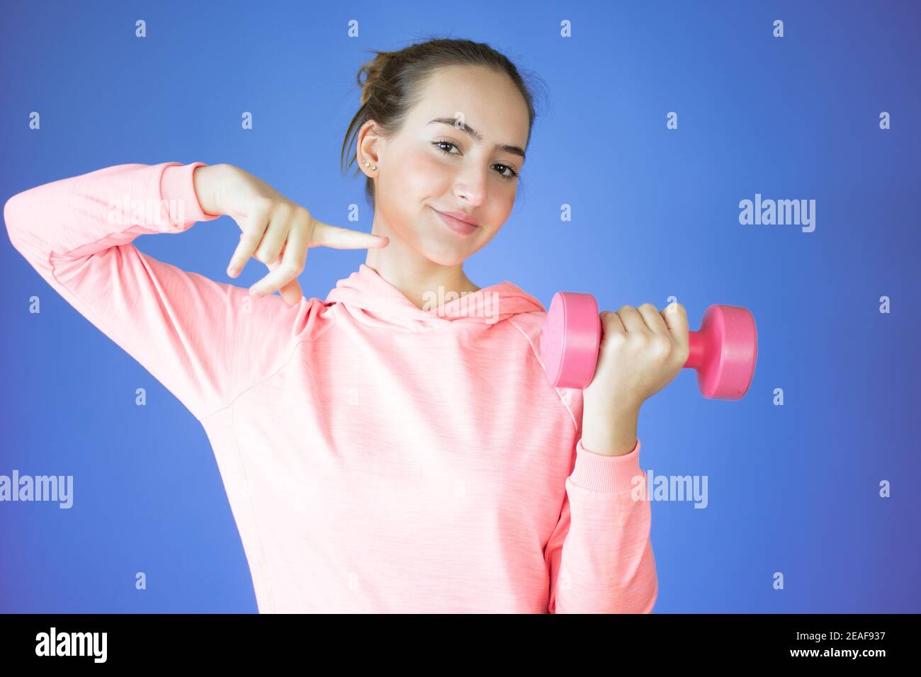 Portrait of pretty sporty girl holding a weight Stock Photo - Alamy