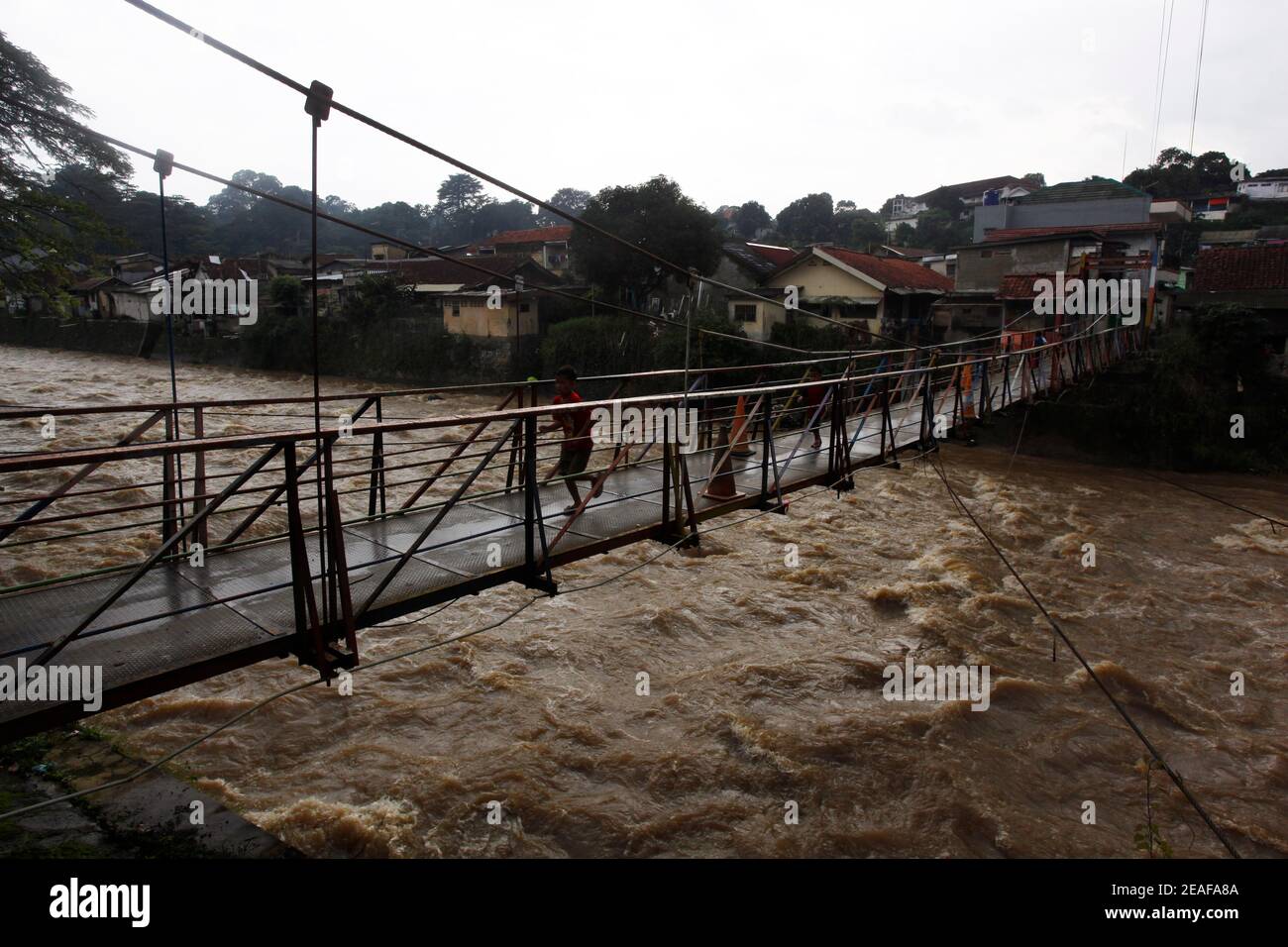A children walk on the bridge during the Ciliwung river water level ...