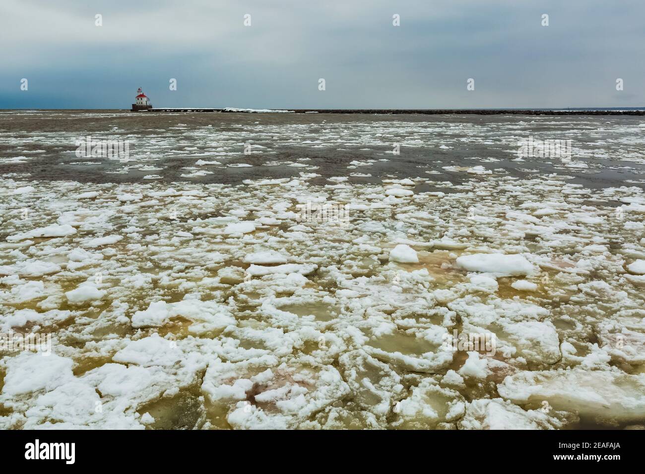 Superior Entry Lighthouse with ice along the Lake Superior shore in ...