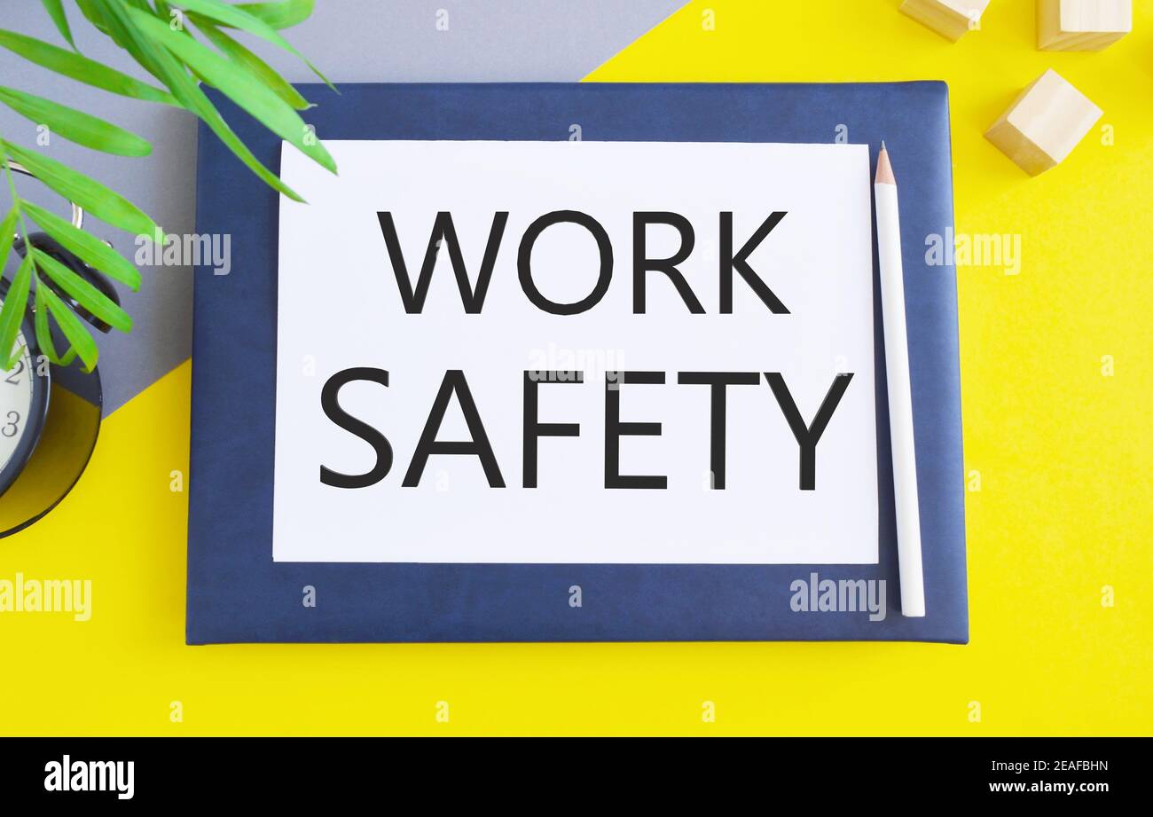 Work Safety message text written on white paper above Notebook ...