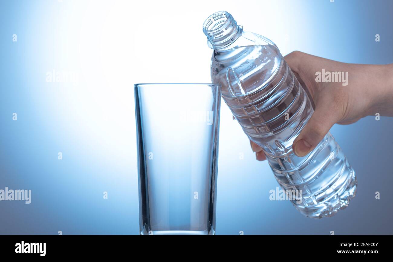 Plastic bottle with water in a female hand. Empty glass beaker Stock ...