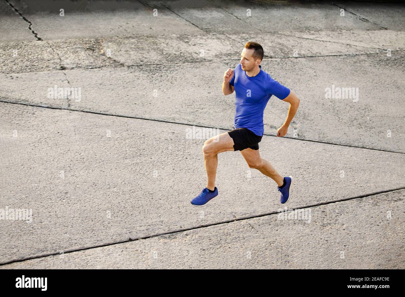 man athlete runner running on concrete road Stock Photo - Alamy