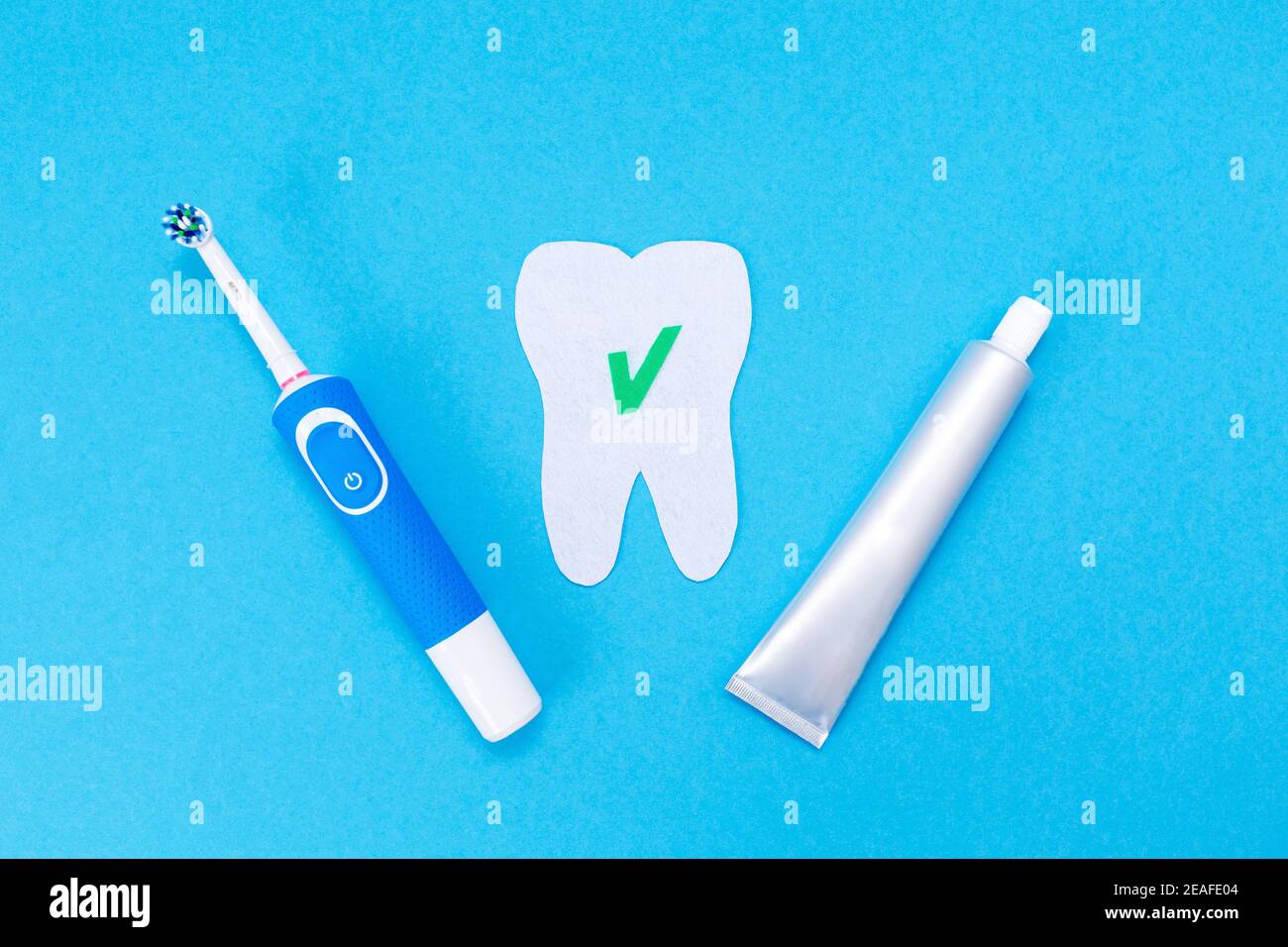 Electric toothbrush, toothpaste, a tooth cut out of felt with a green ...