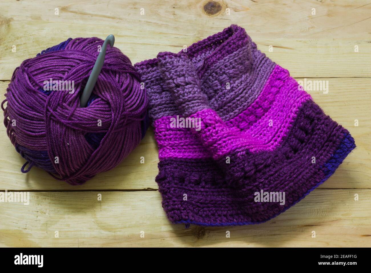 colorful ball of wool and piece of woven winter garment with crochet ...