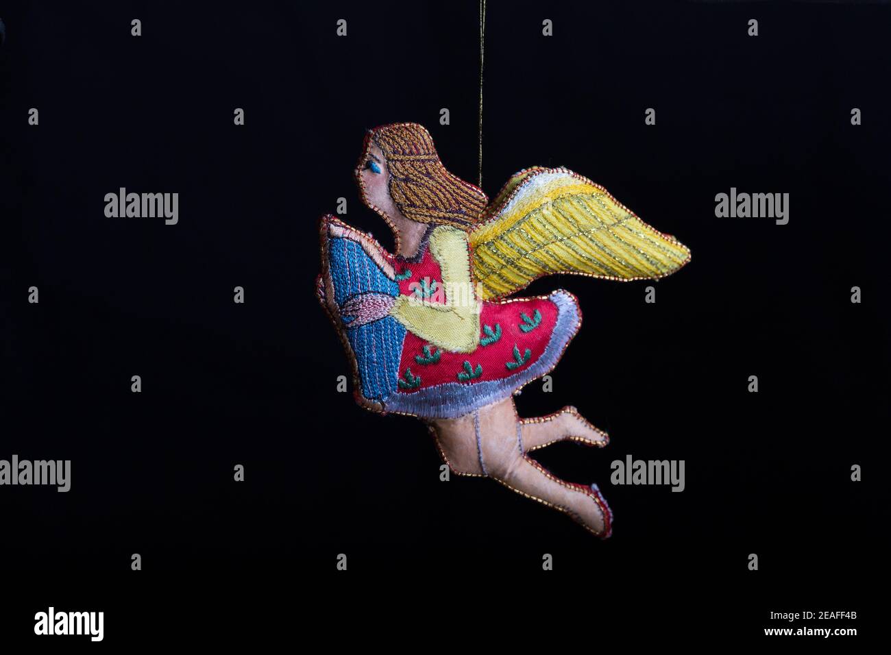 Christmas decorations on string angels with black background Stock ...