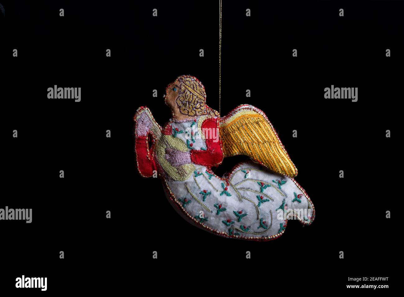 Christmas decorations on string angels with black background Stock ...
