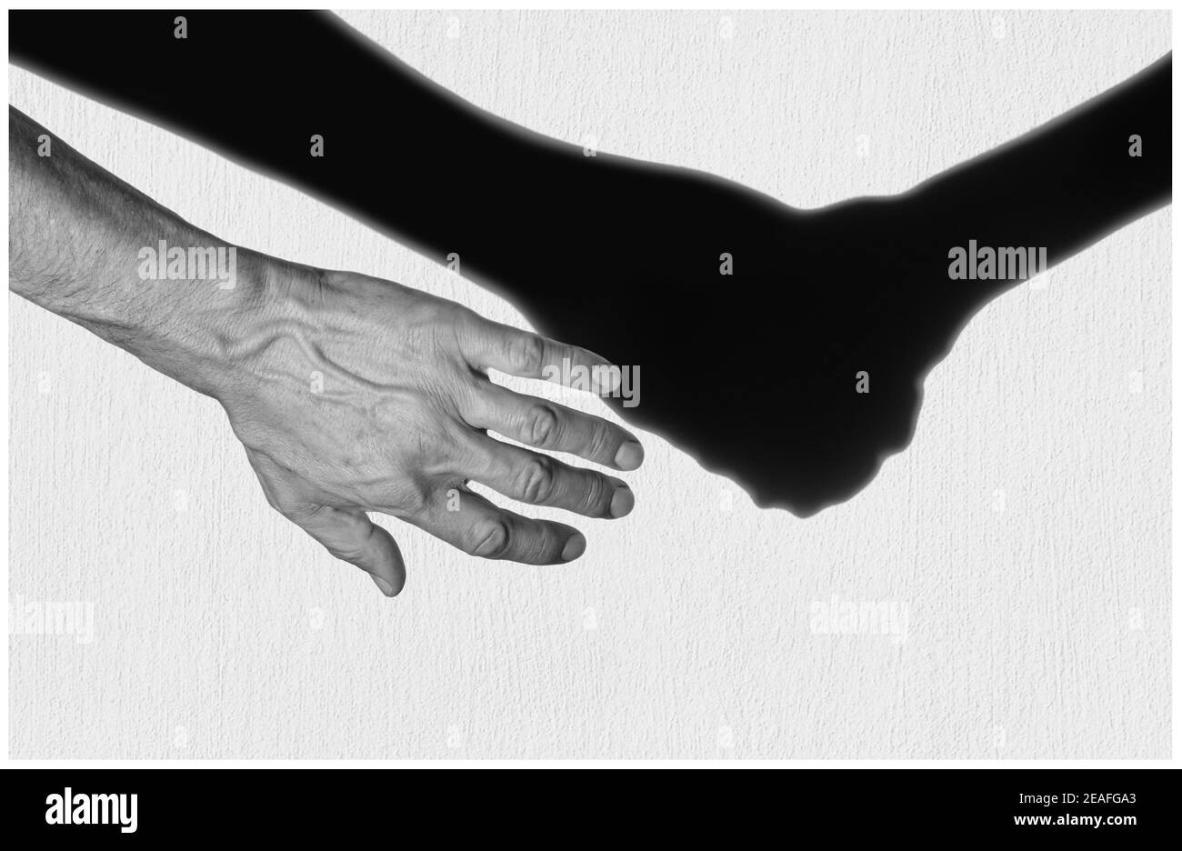 Missing you - a single lonely hand with a shadow of two hands holding ...