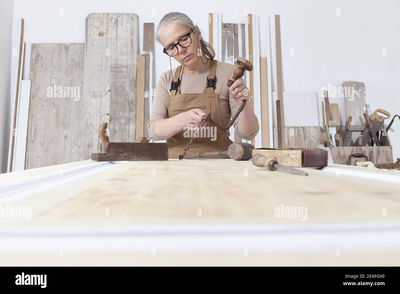wood crafts, woman artisan carpenter works wood with old handle tools ...