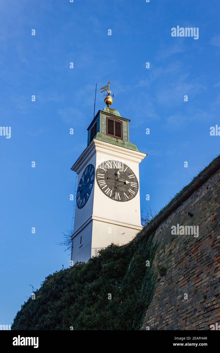 Low angle shot of a white tower with a big clock and a monument on top ...