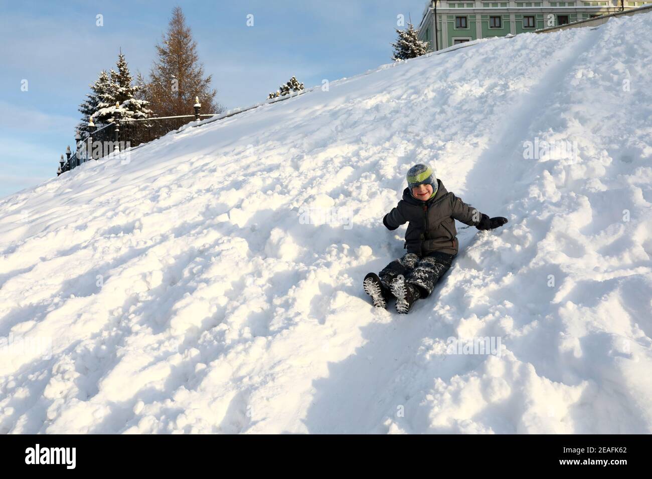 Boy rolling down snowy hill in Kazan Kremlin, Russia Stock Photo - Alamy
