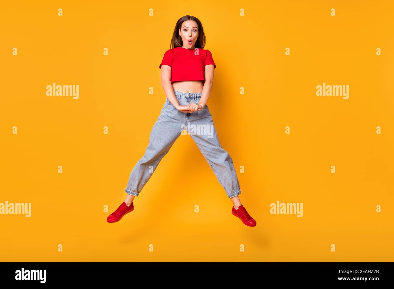 Photo of shocked jumping lady open mouth wear red crop top jeans shoes ...