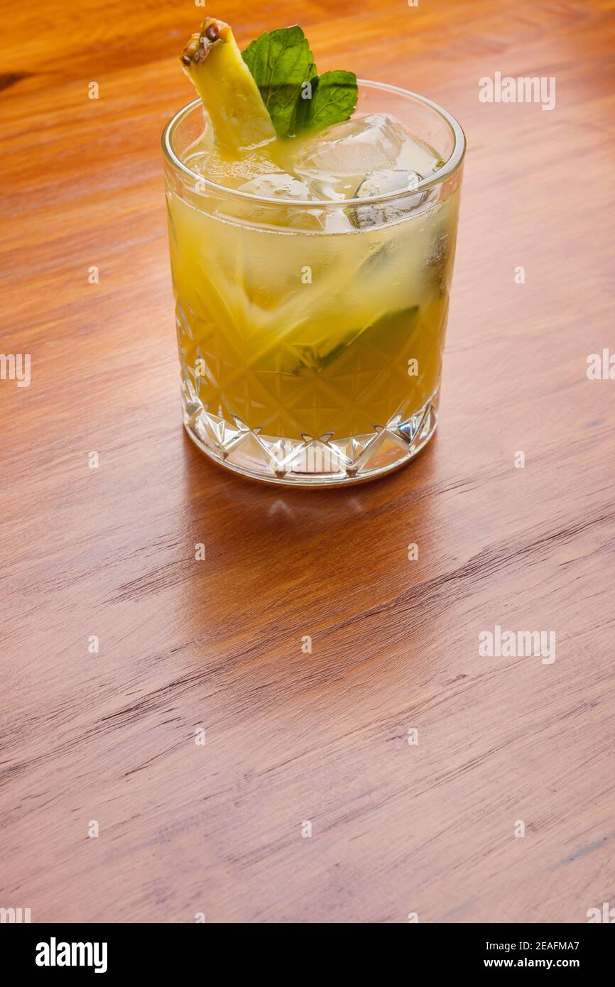 Closeup shot of a glass of alcoholic cocktail with fruit mixology on a ...